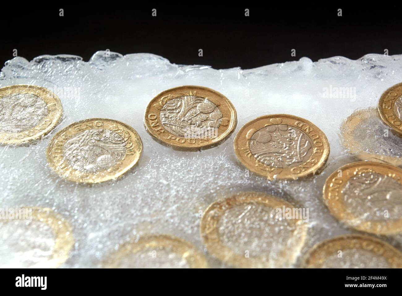 Photograph of £1 coins set in a block of ice Stock Photo - Alamy