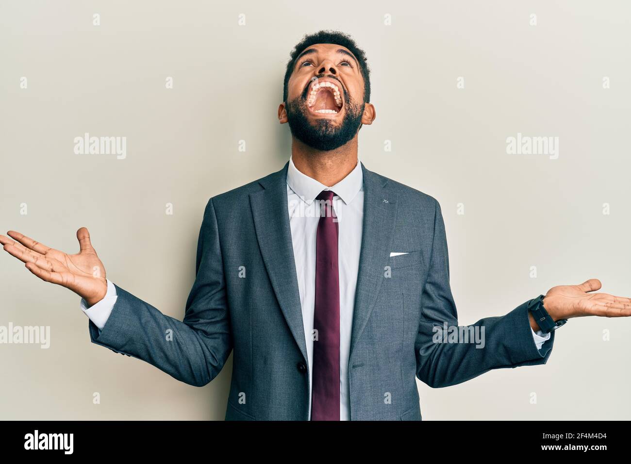 Handsome hispanic man with beard wearing business suit and tie crazy ...
