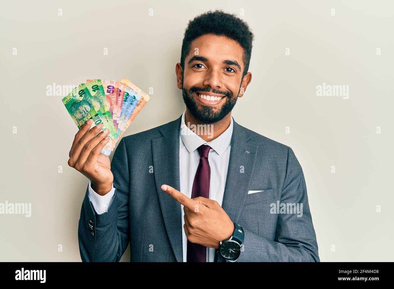 Handsome hispanic business man with beard holding south african rand ...