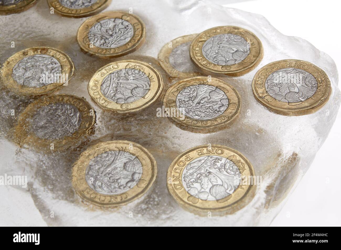 Photograph of £1 coins set in a block of ice Stock Photo - Alamy