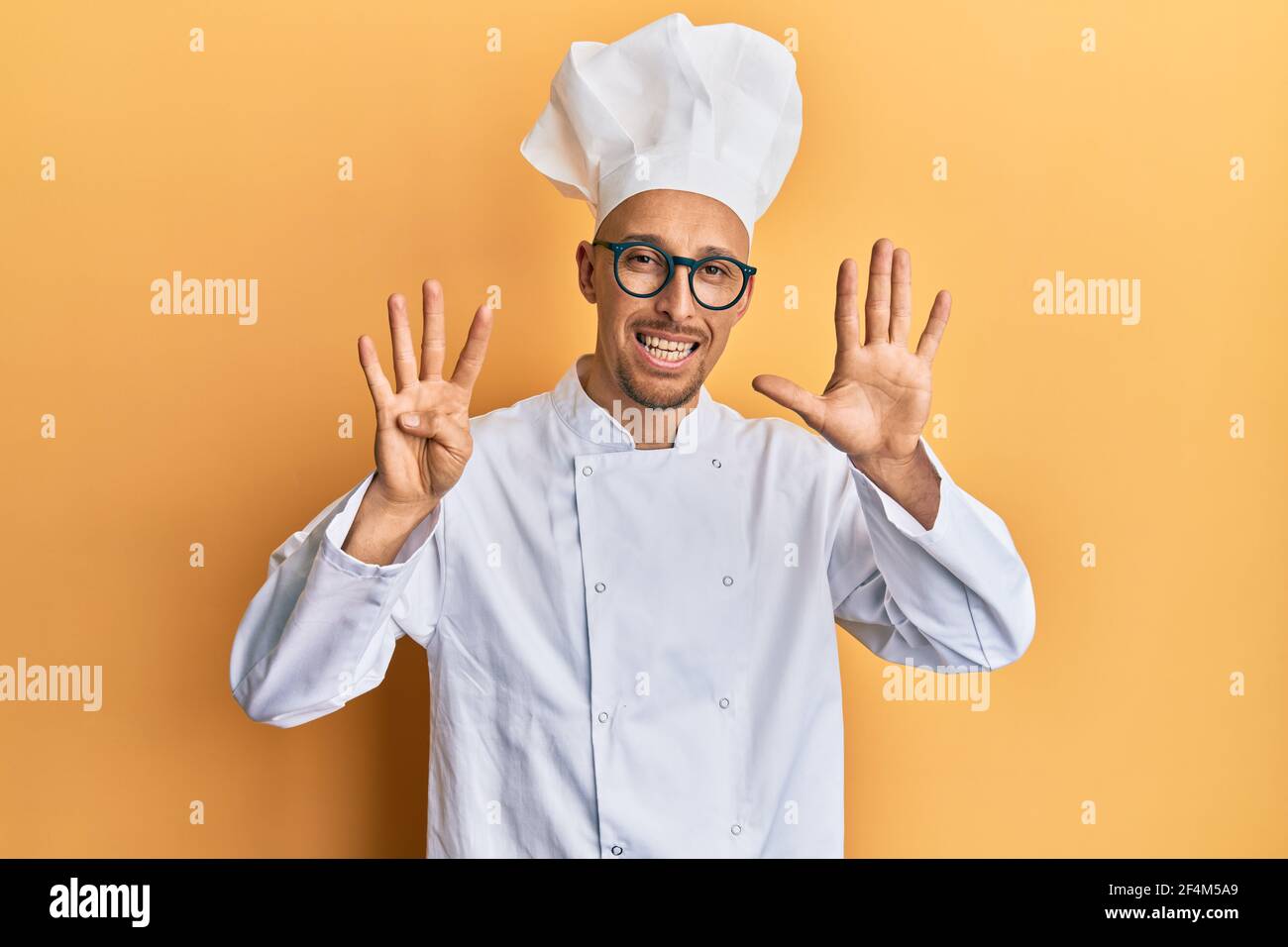 Bald man with beard wearing professional cook uniform showing and ...