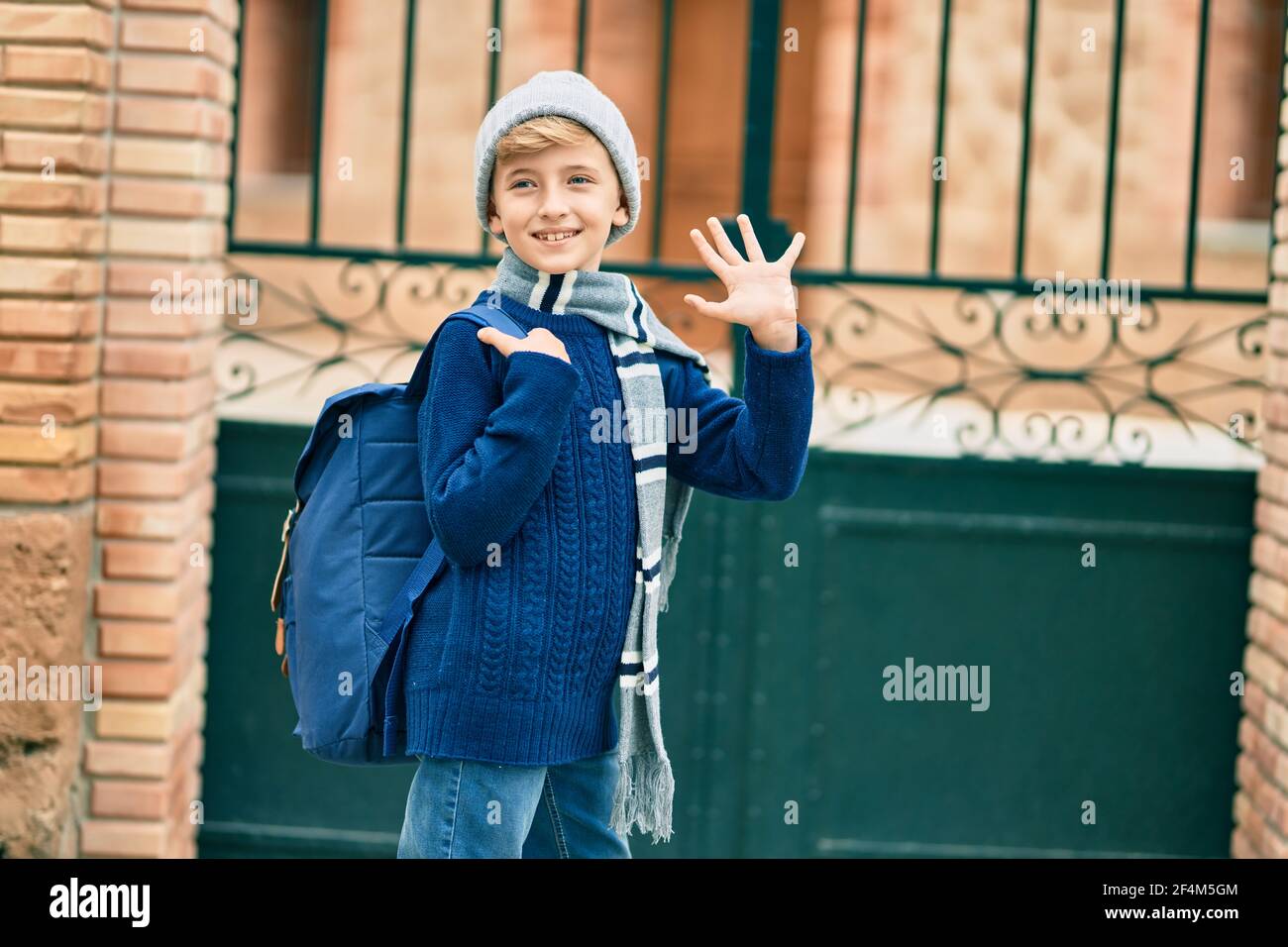 Adorable blond student kid saying goodbye with hand getting in the ...