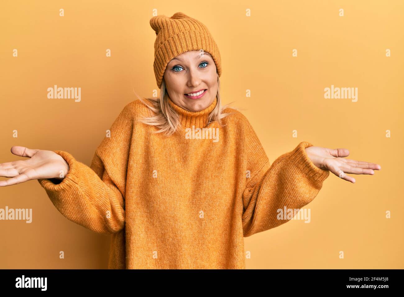 Middle age caucasian woman wearing wool winter sweater and hat clueless ...