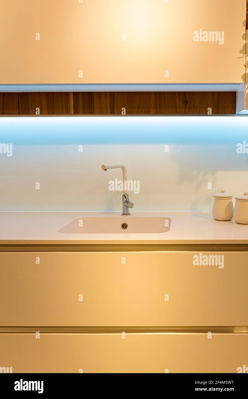 White sink and faucet set against light beige surfaces. Trendy modern ...