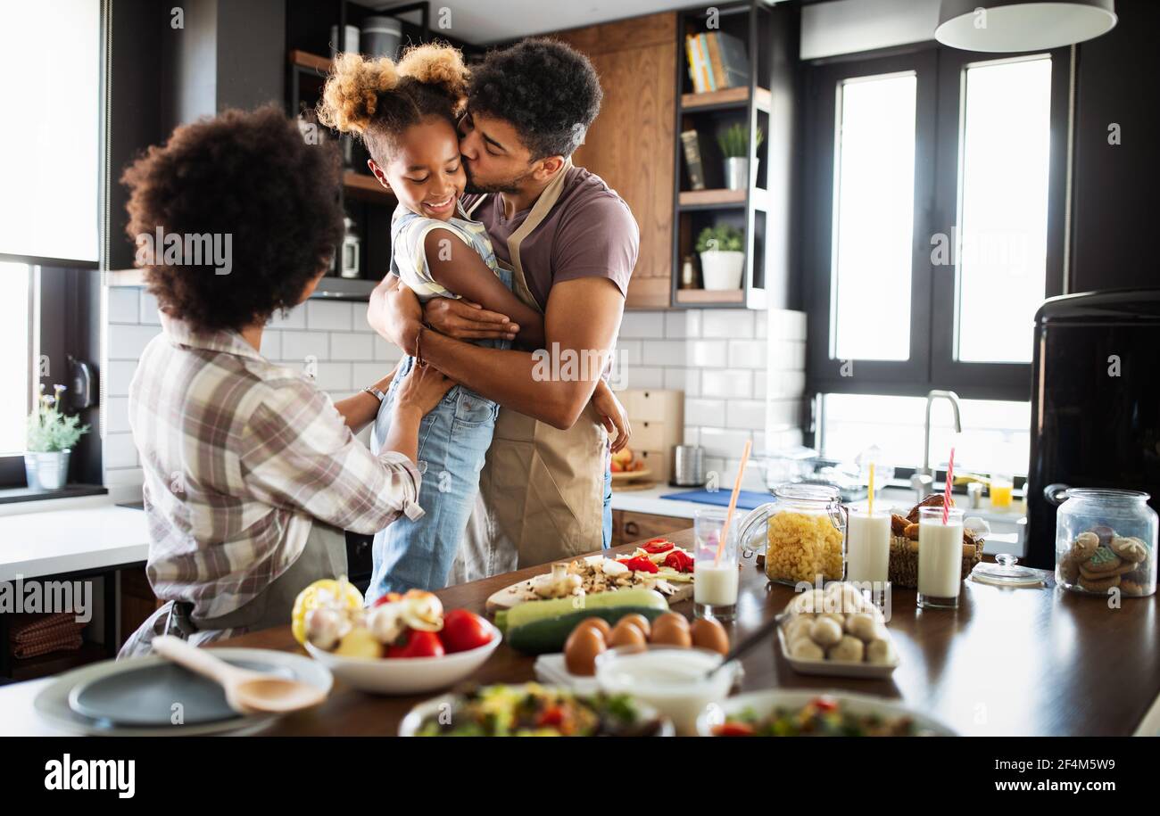 Happy family cooking together food in the kitchen Stock Photo - Alamy