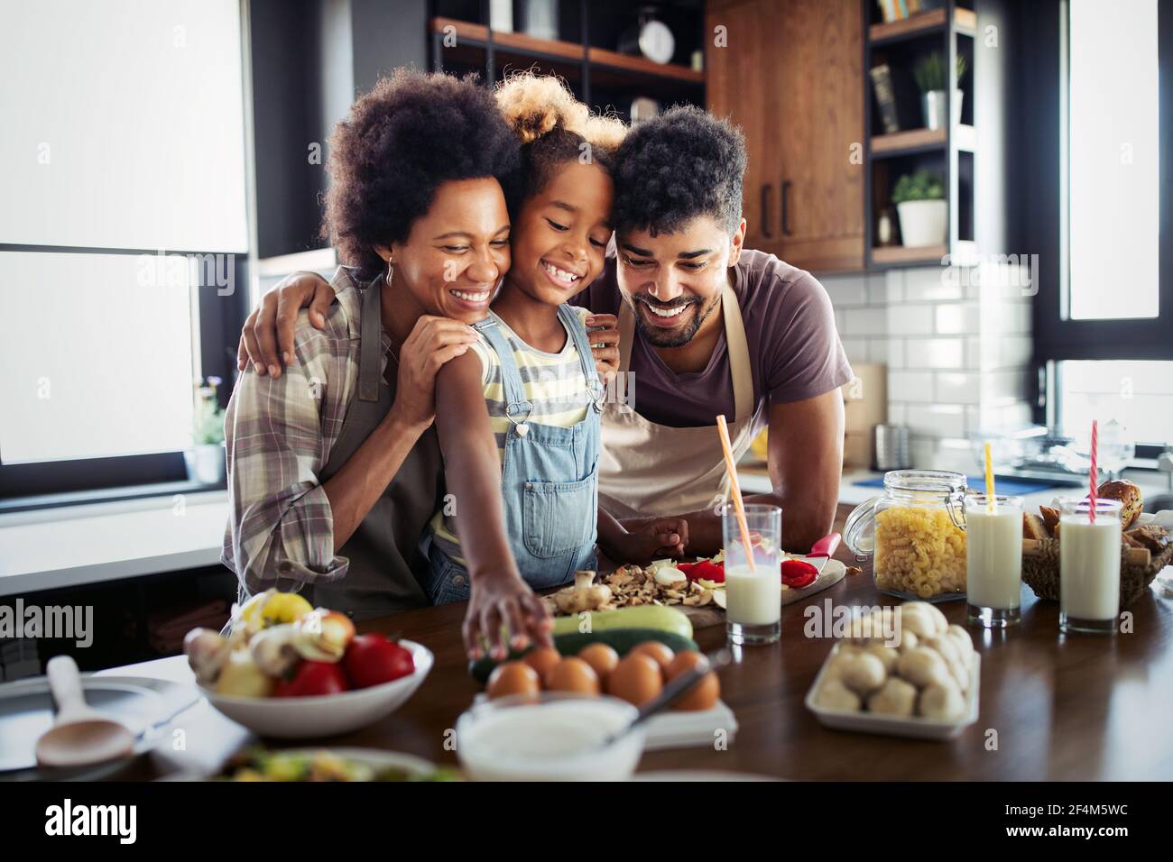 Happy family cooking together food in the kitchen Stock Photo - Alamy