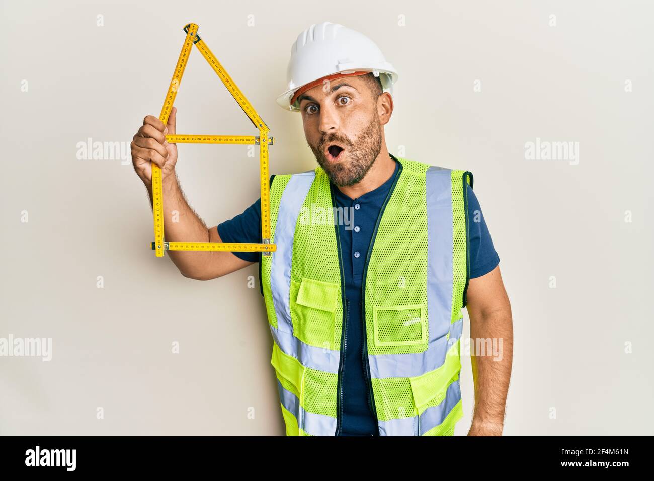 Handsome man with beard wearing hardhat holding build project scared ...