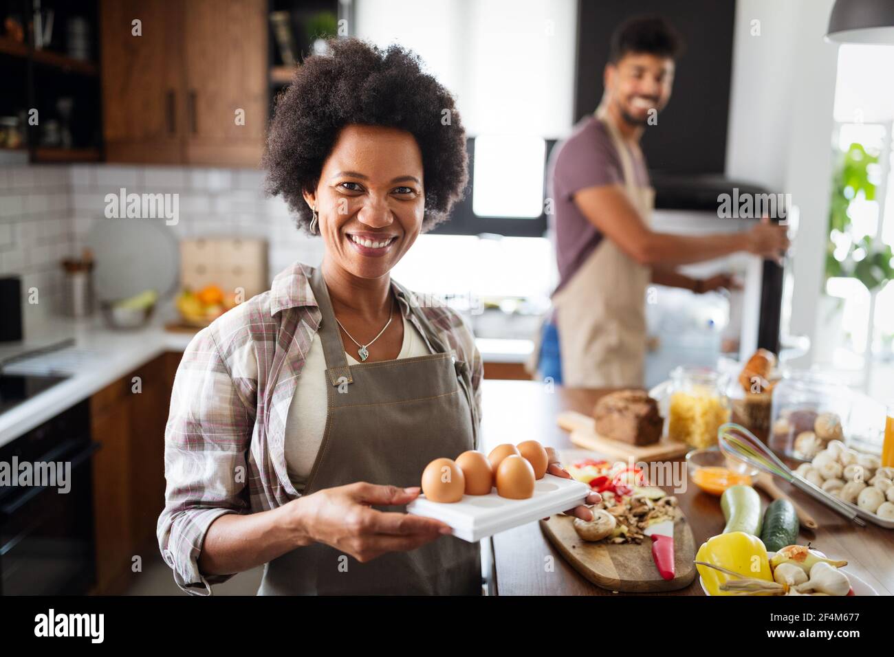 Happy young couple cooking together in the kitchen at home Stock Photo ...