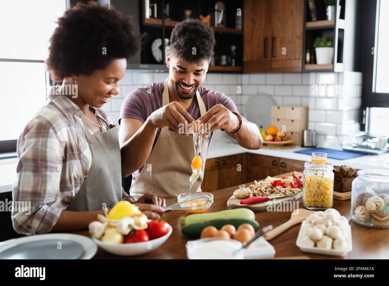 Happy black couple cooking and tasting healthy food in kitchen Stock ...
