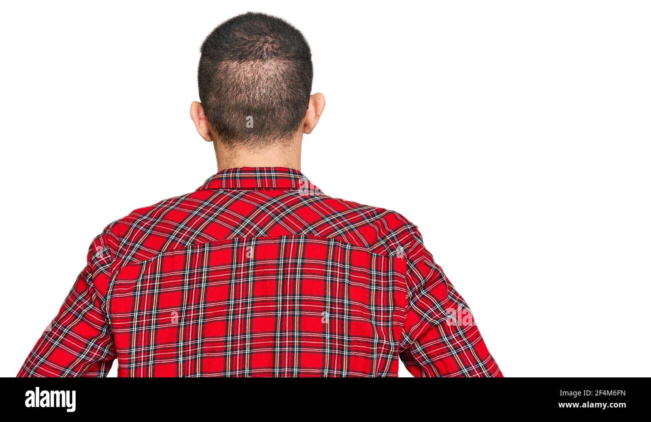 Hispanic young man wearing casual clothes standing backwards looking ...