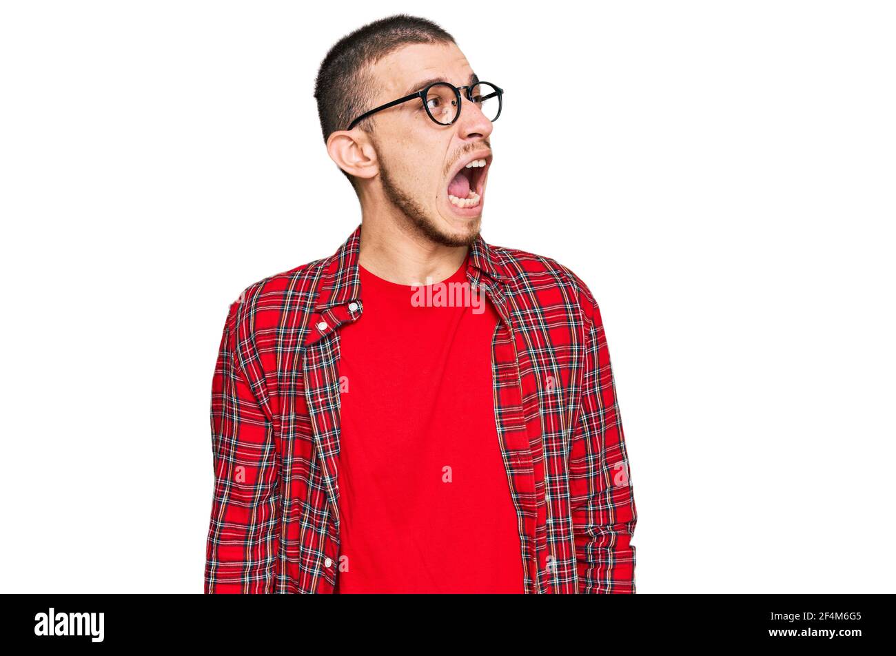 Hispanic young man wearing casual clothes angry and mad screaming ...