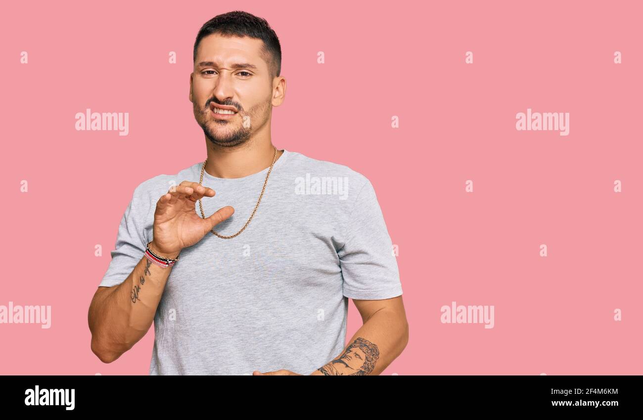 Handsome man with tattoos wearing 90s style disgusted expression ...