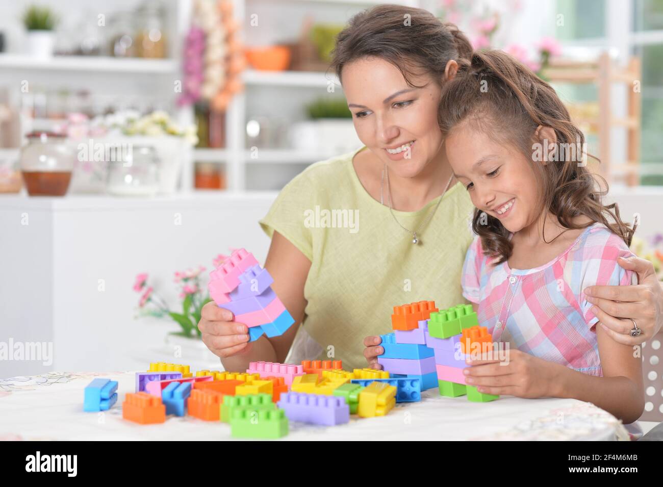 Young mother and little daughter playing lego game Stock Photo - Alamy