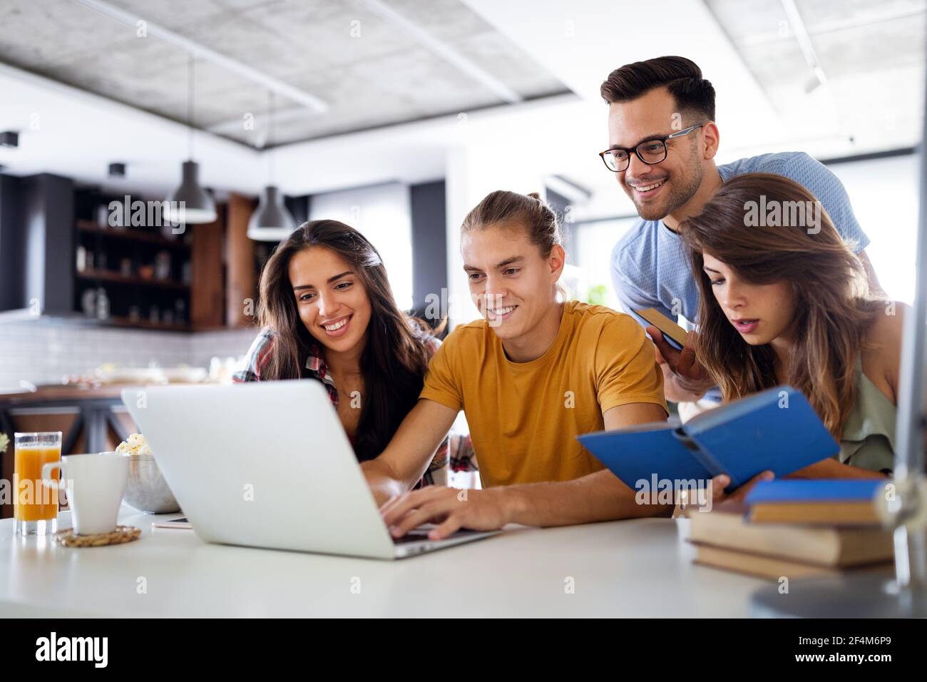 Happy group of young students studying together Stock Photo - Alamy