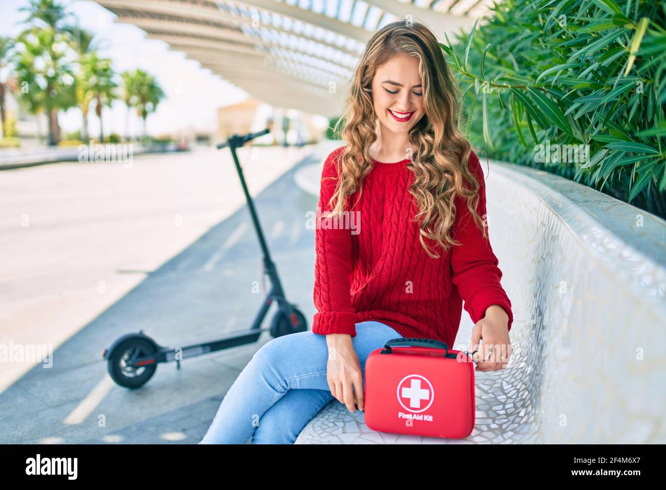 Young blonde girl smiling happy opening first aid kit sitting on the ...