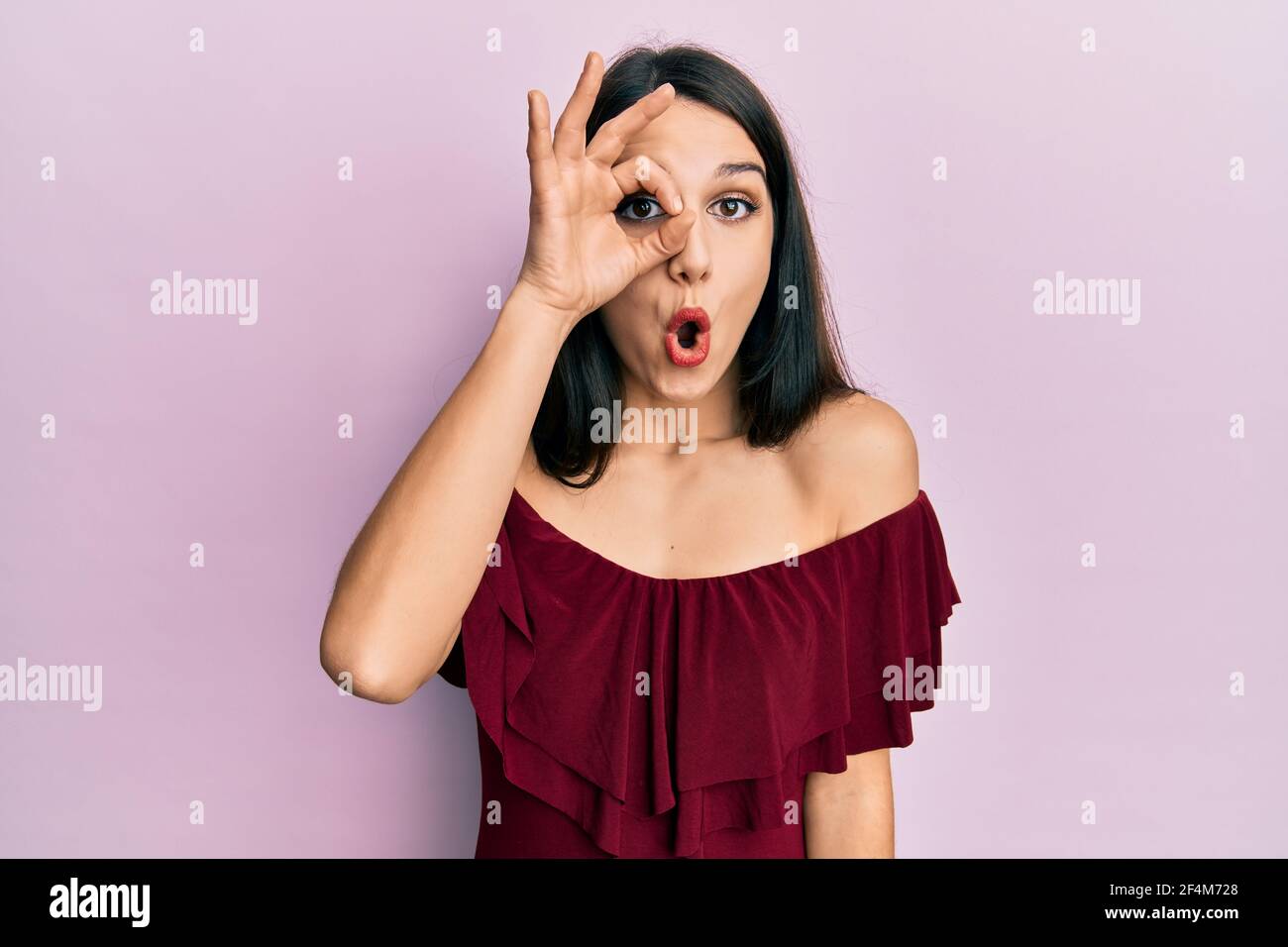 Young hispanic woman wearing casual clothes doing ok gesture shocked ...