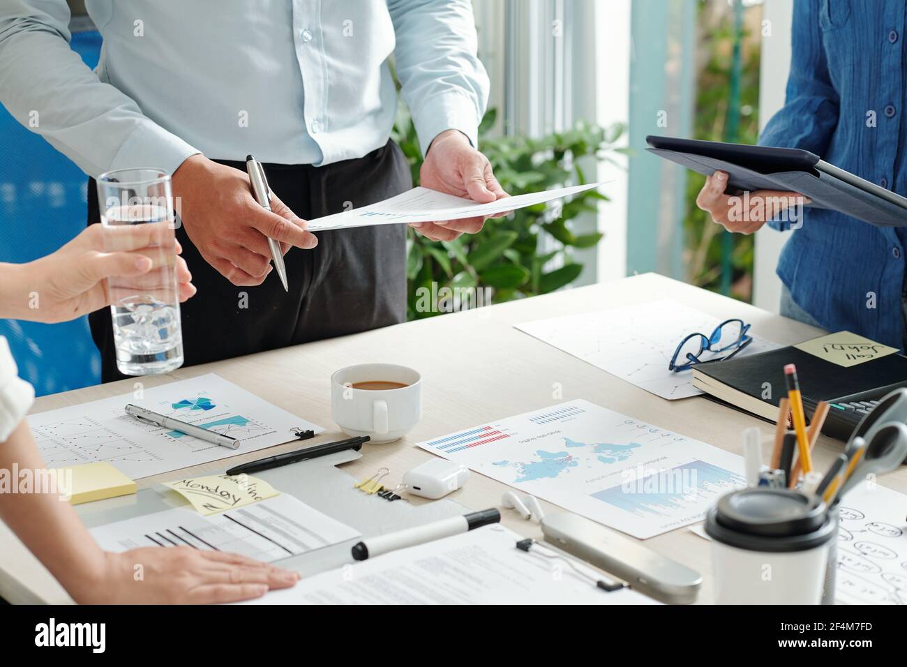 Hands of businessman taking chart from table in meeting room and ...