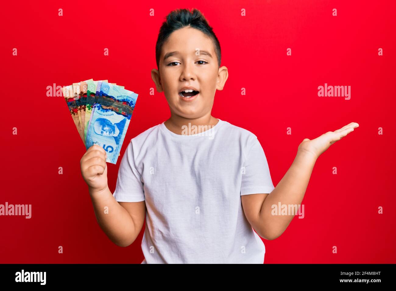 Little boy hispanic kid holding canadian dollars celebrating ...