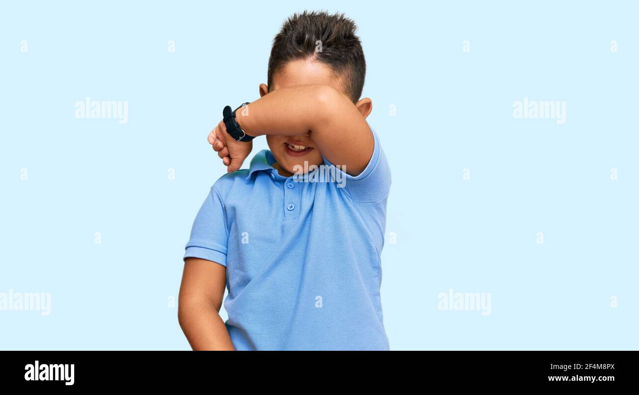 Little boy hispanic kid wearing casual clothes covering eyes with arm ...