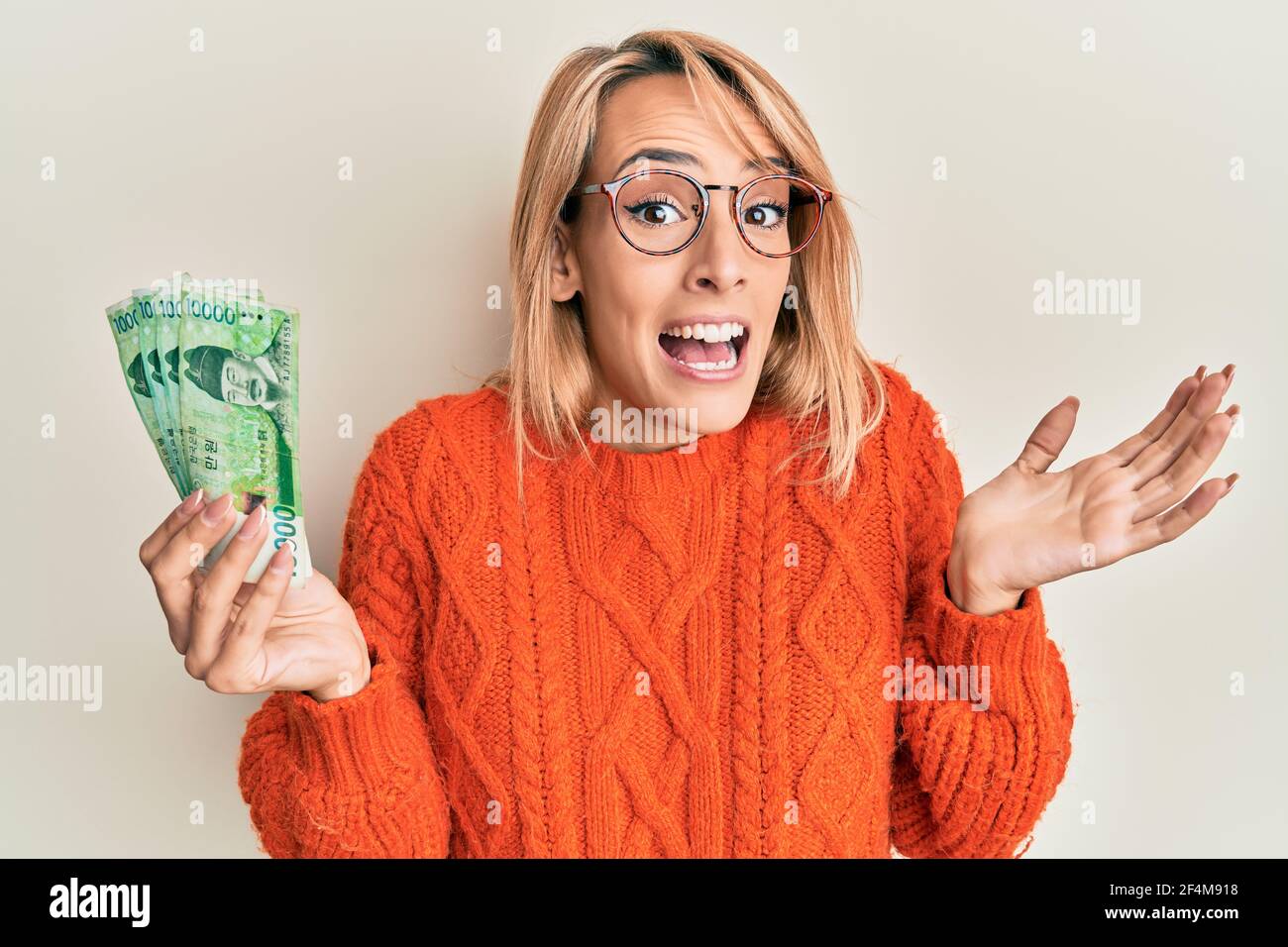Beautiful blonde woman holding 10000 south korean won banknotes ...
