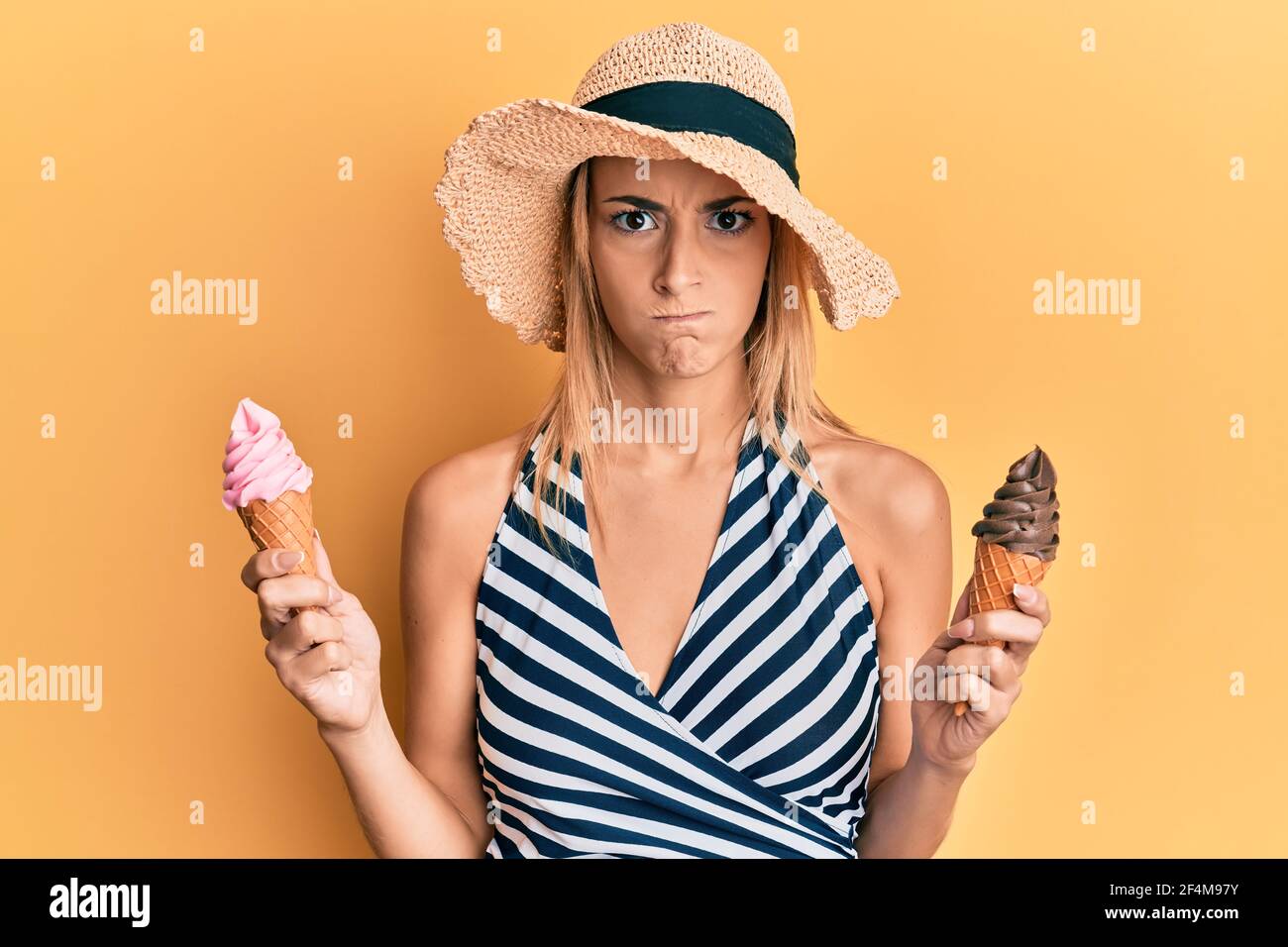 Beautiful blonde woman wearing summer style holding ice cream skeptic ...