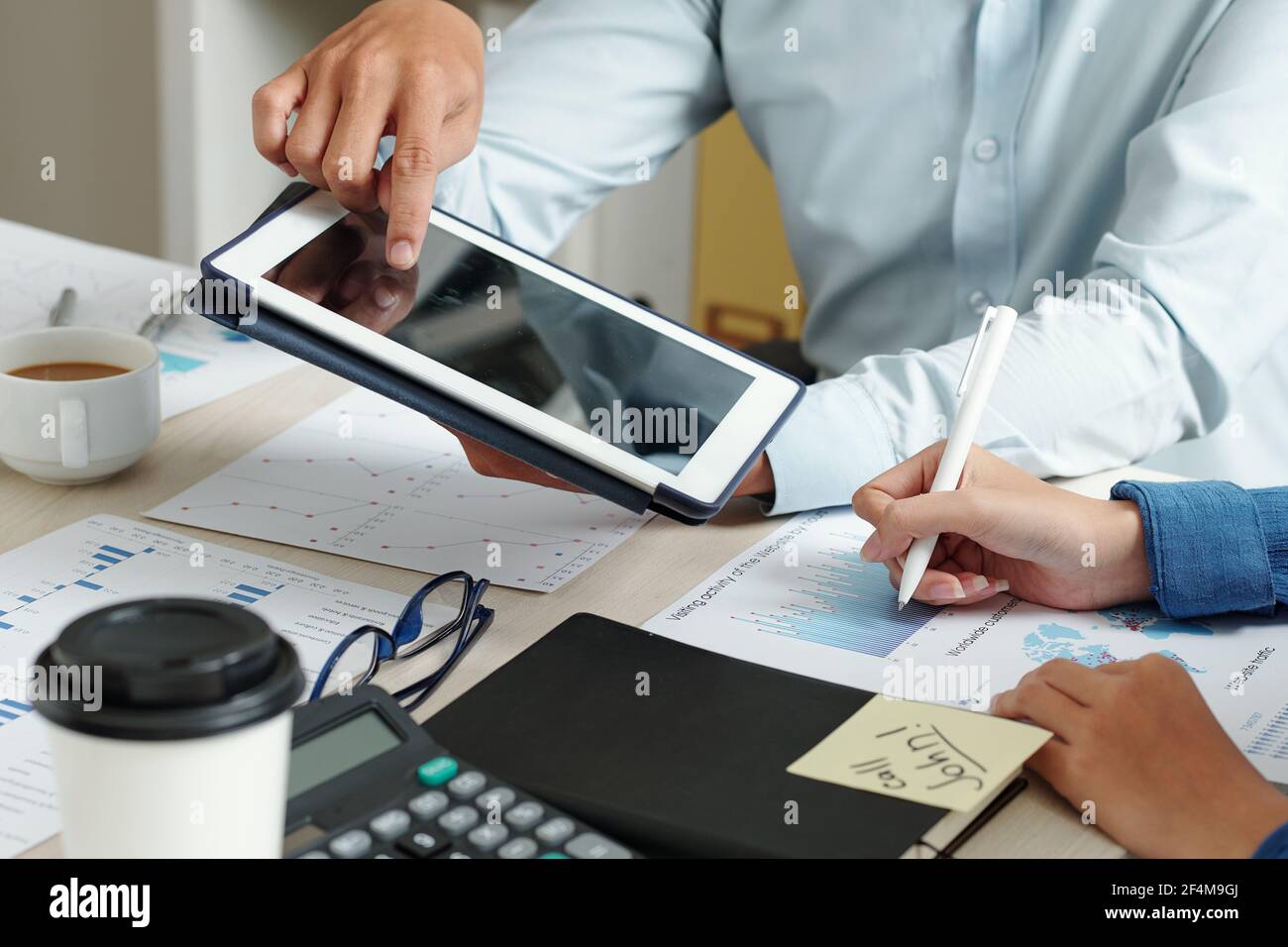 Close-up image of businessman pointing at screen of tablet computer ...