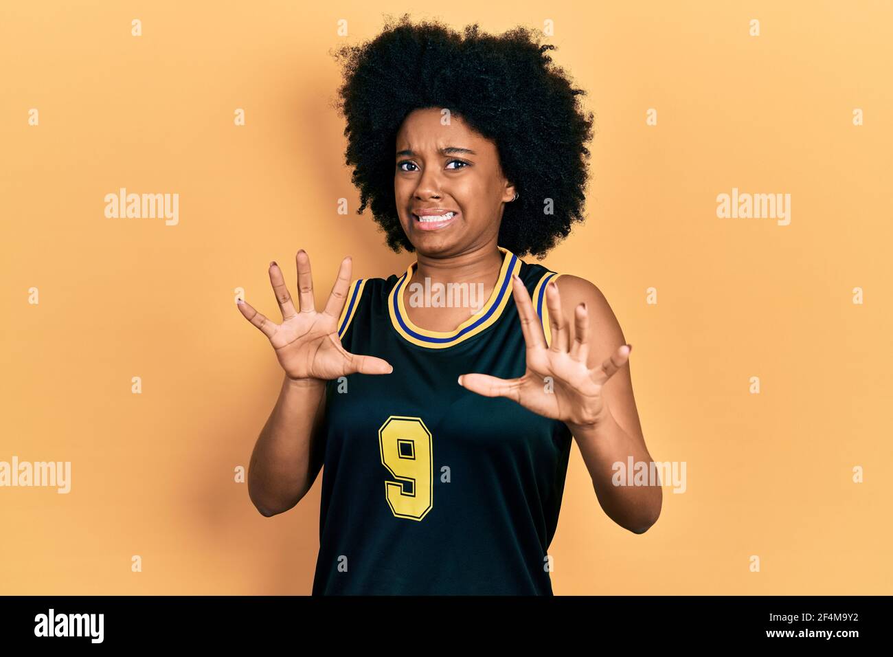 Young african american woman wearing basketball uniform afraid and ...