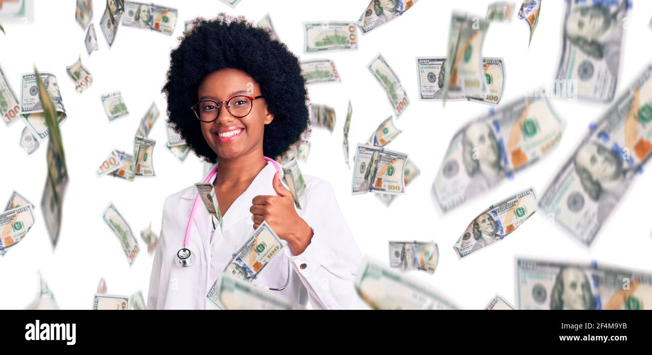 Young african american woman wearing doctor coat and stethoscope doing ...