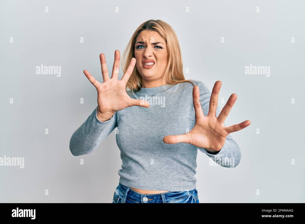 Young caucasian woman wearing casual clothes afraid and terrified with ...