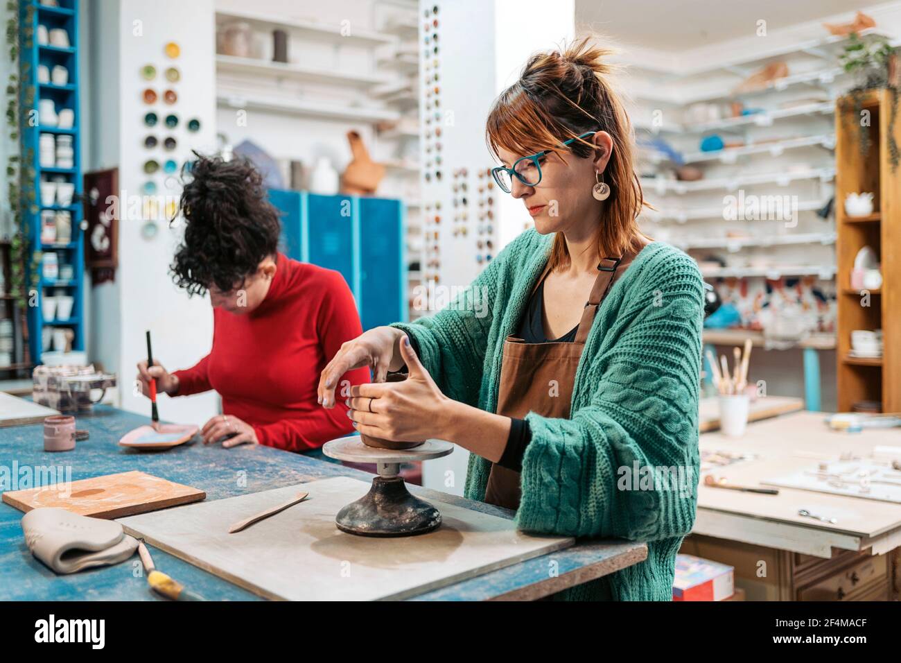 Stock photo of focused woman shaping clay during her pottery class ...