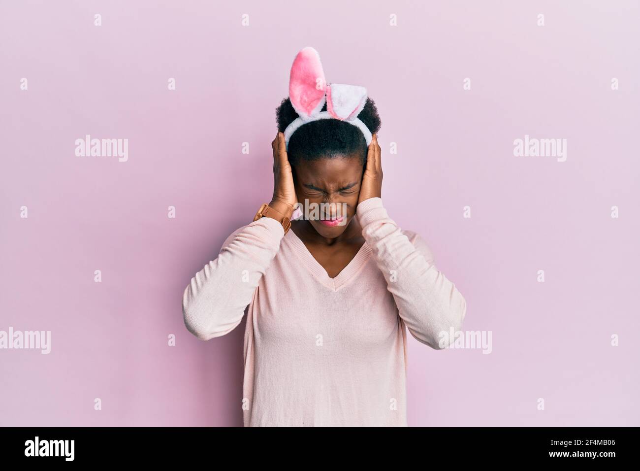 Young african american girl wearing cute easter bunny ears suffering ...