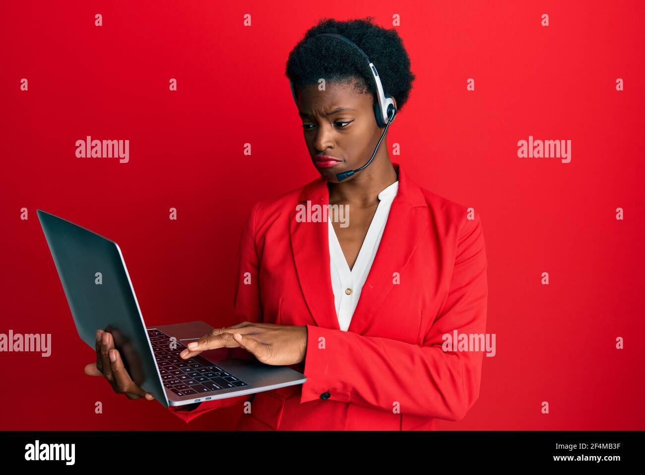 Young african american girl working at the office wearing operator ...