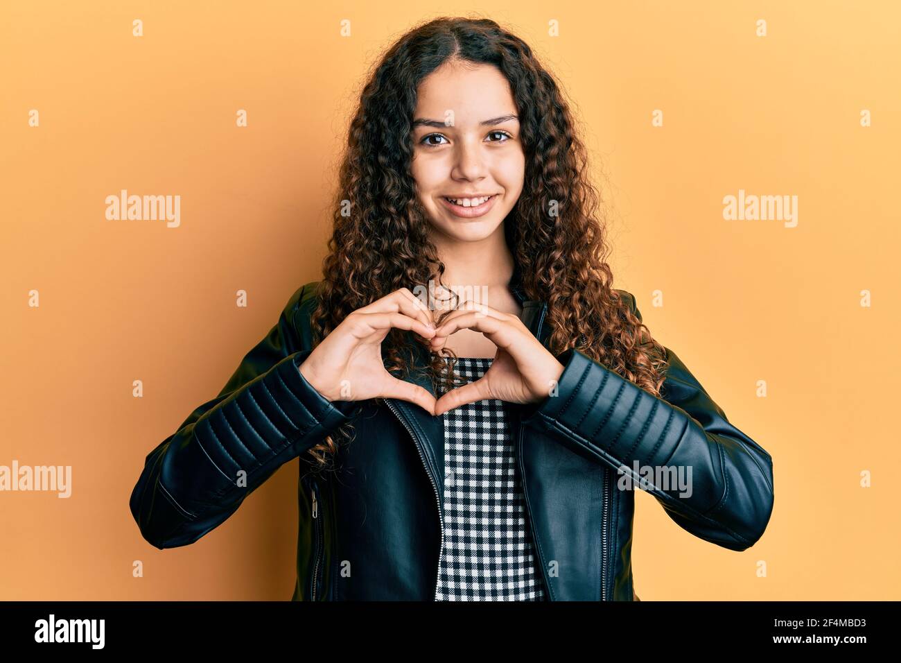 Teenager hispanic girl wearing black leather jacket smiling in love ...