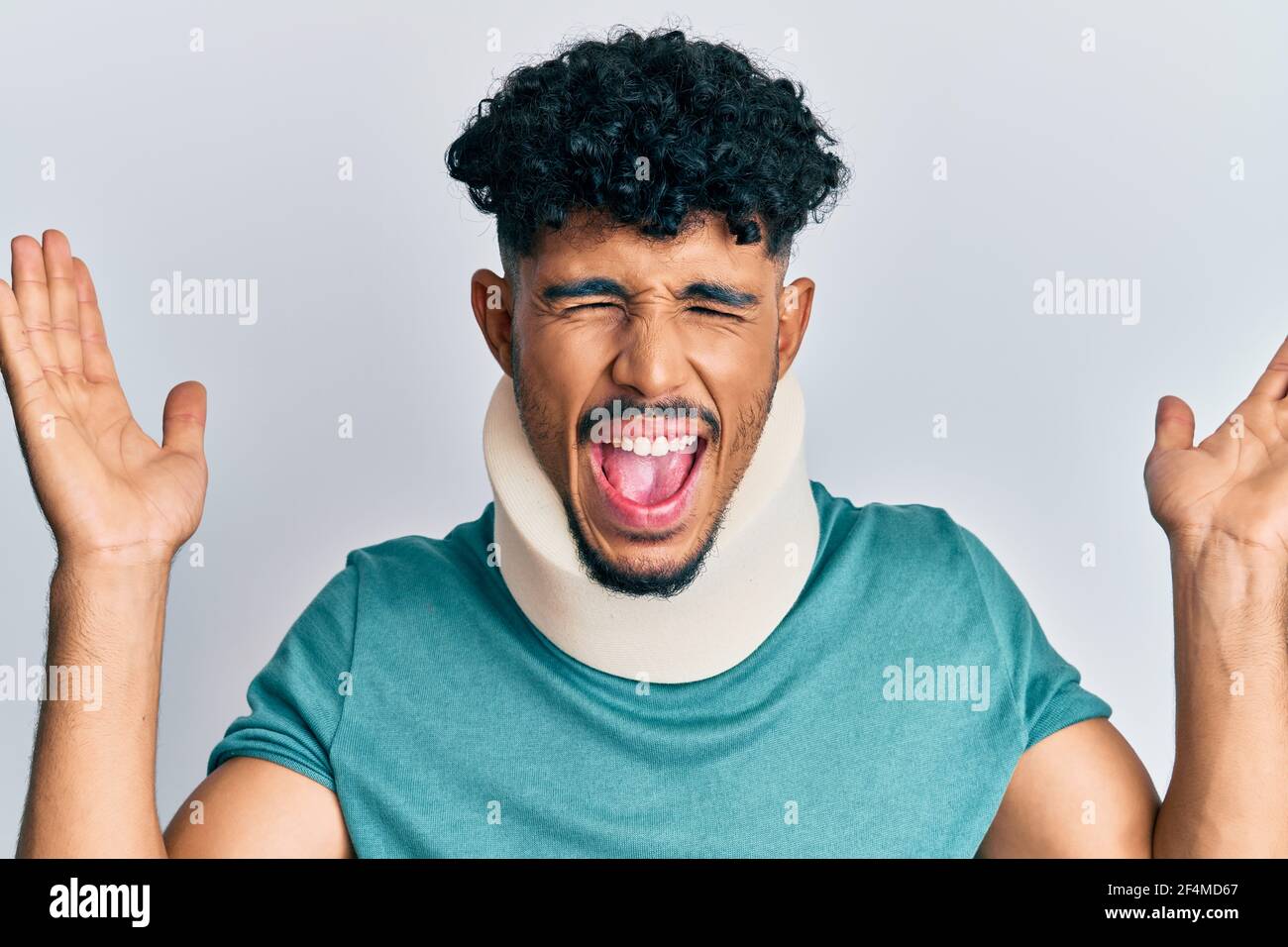 Young arab handsome man wearing cervical neck collar celebrating mad ...