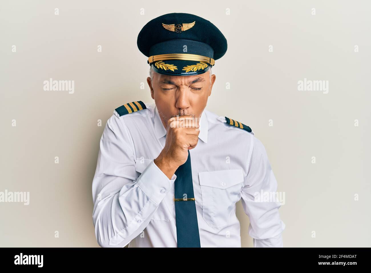 Handsome middle age mature man wearing airplane pilot uniform feeling ...