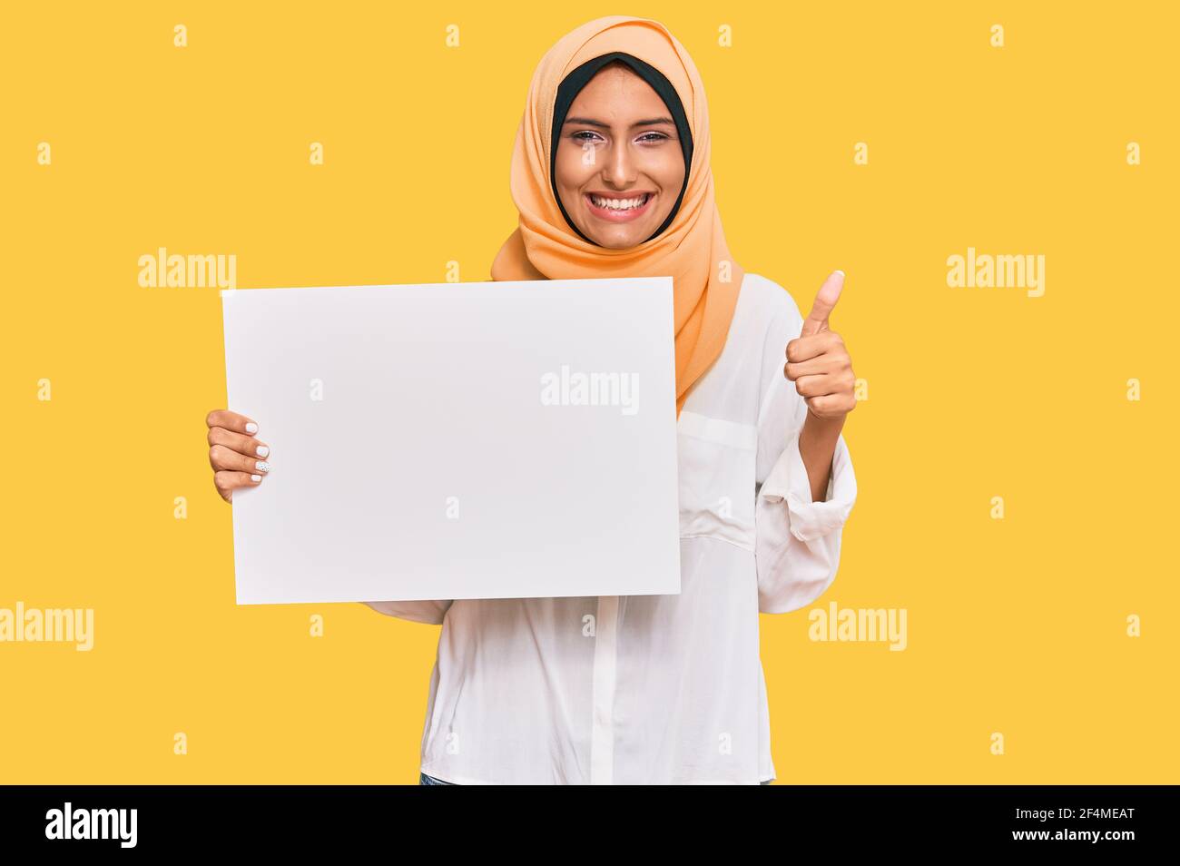 Young brunette arab woman wearing traditional islamic hijab holding ...
