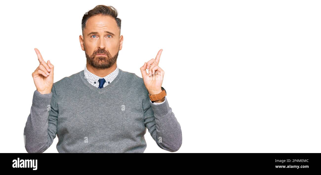 Handsome middle age man wearing business clothes pointing up looking ...