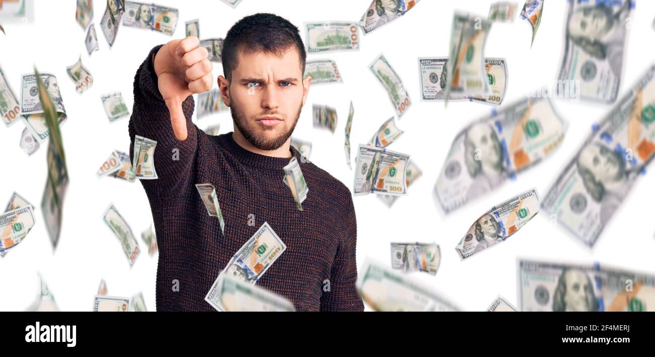 Young handsome man wearing casual sweater looking unhappy and angry ...
