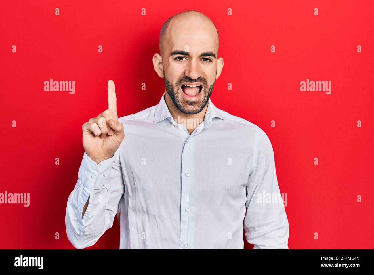 Young bald man wearing elegant clothes smiling with an idea or question ...
