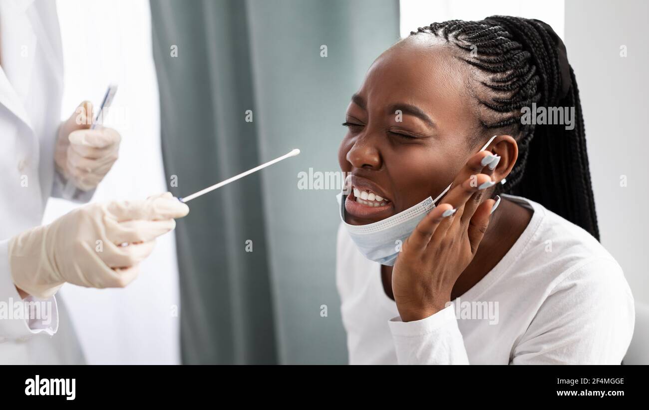 Doctor taking PCR test sample from scared infected afro woman Stock ...