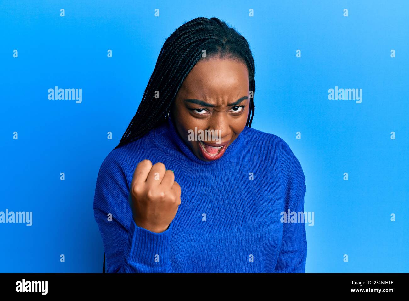 Young african american woman wearing casual winter sweater angry and ...