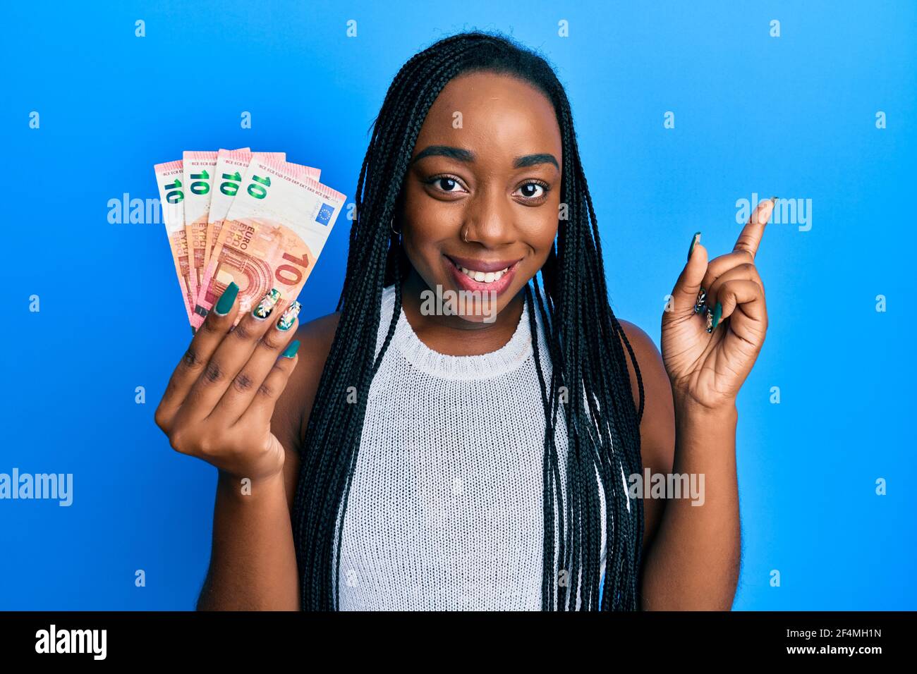Young african american woman holding euro banknotes smiling happy ...