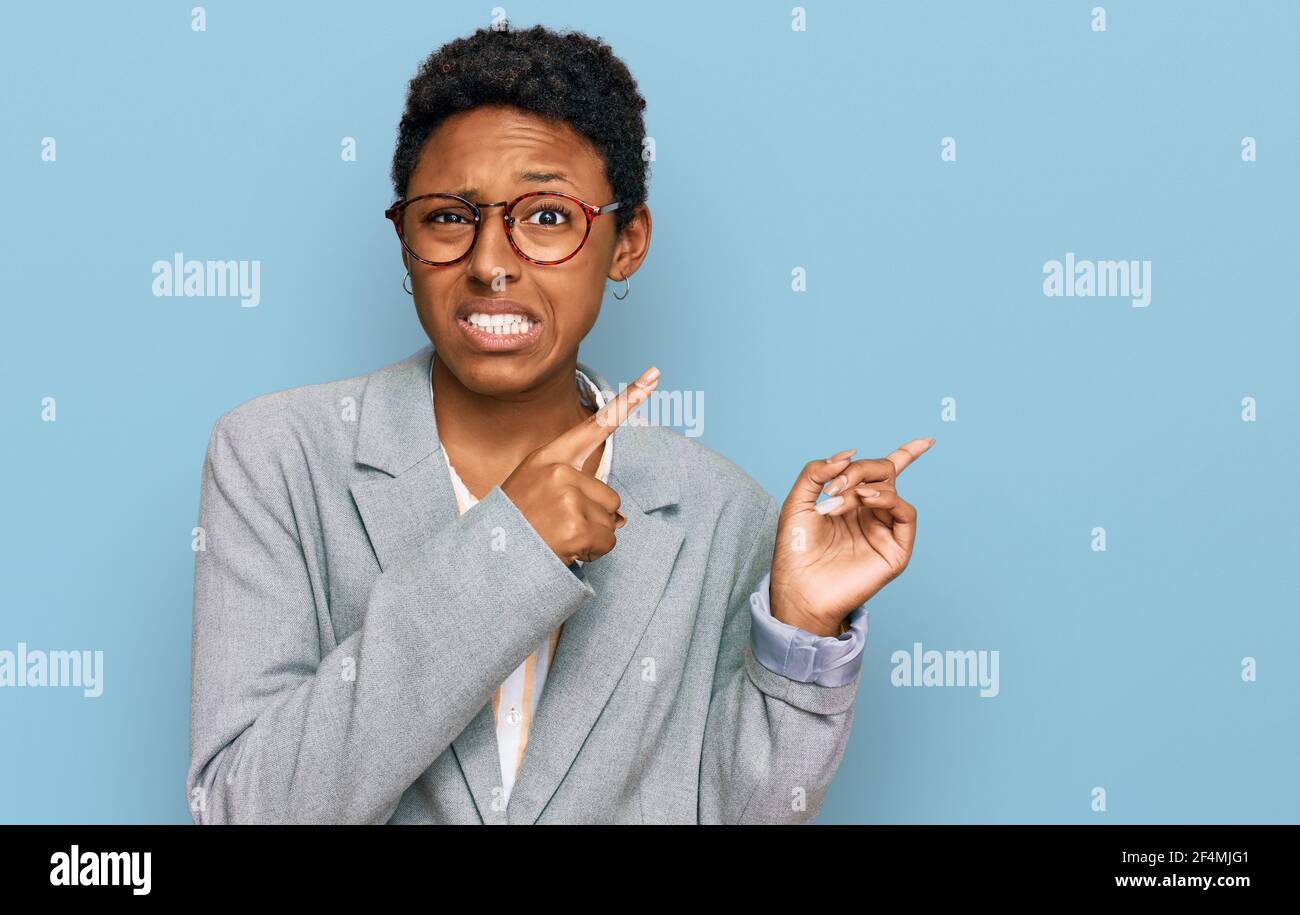 Young african american woman wearing business clothes pointing aside ...