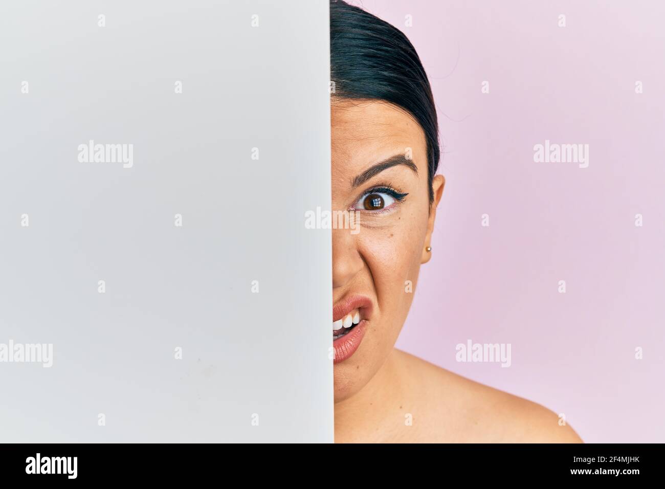 Beautiful brunette woman holding blank empty banner covering half face ...