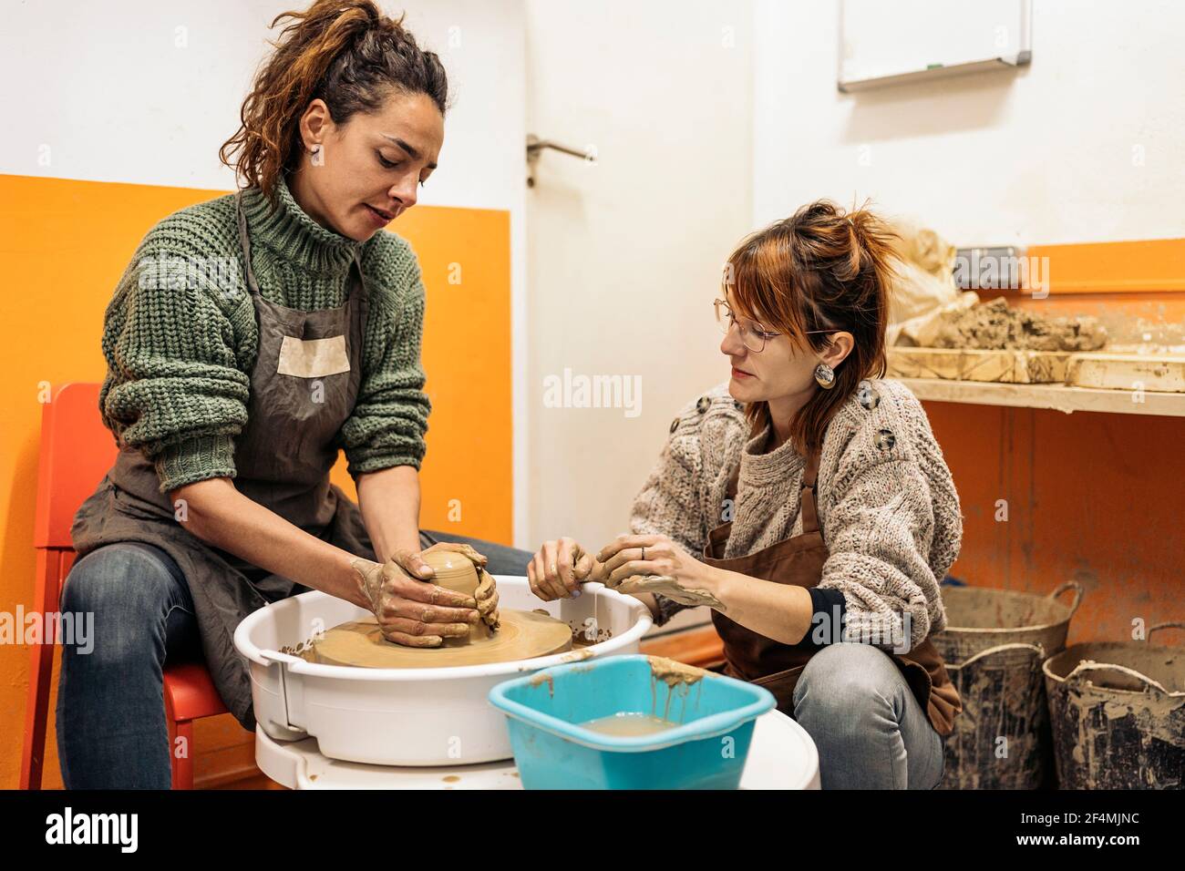 Stock photo of pottery teacher explaining to concentrated woman how to ...