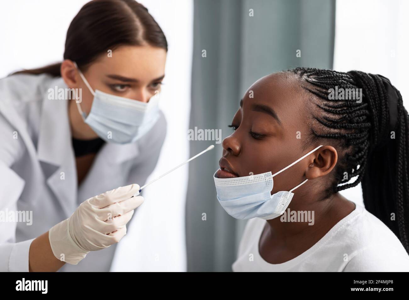 Doctor taking PCR test sample from potentially infected black patient ...
