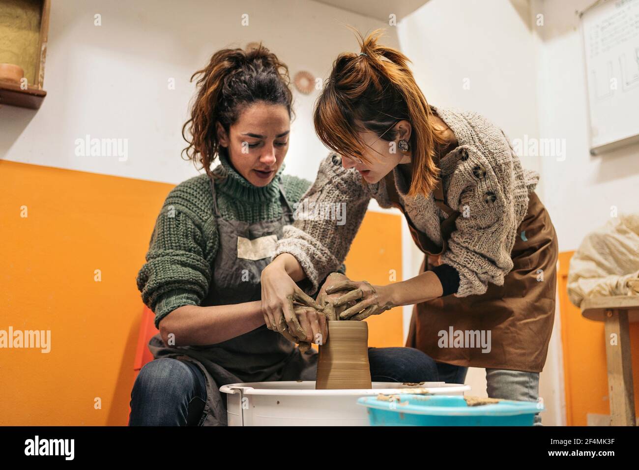 Stock photo of pottery teacher explaining to concentrated woman how to ...