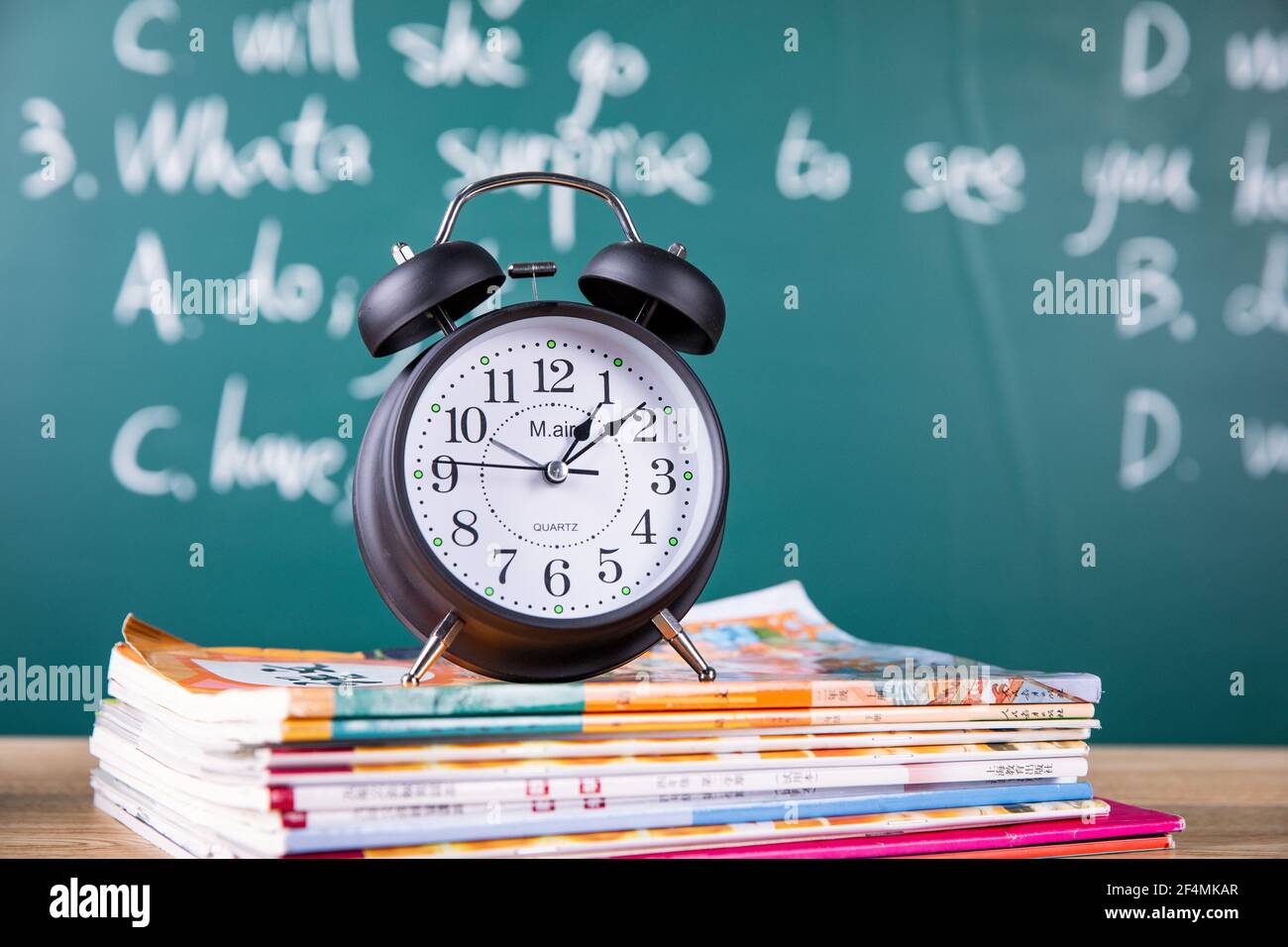 Black vintage alarm clock on the stack of books Stock Photo - Alamy