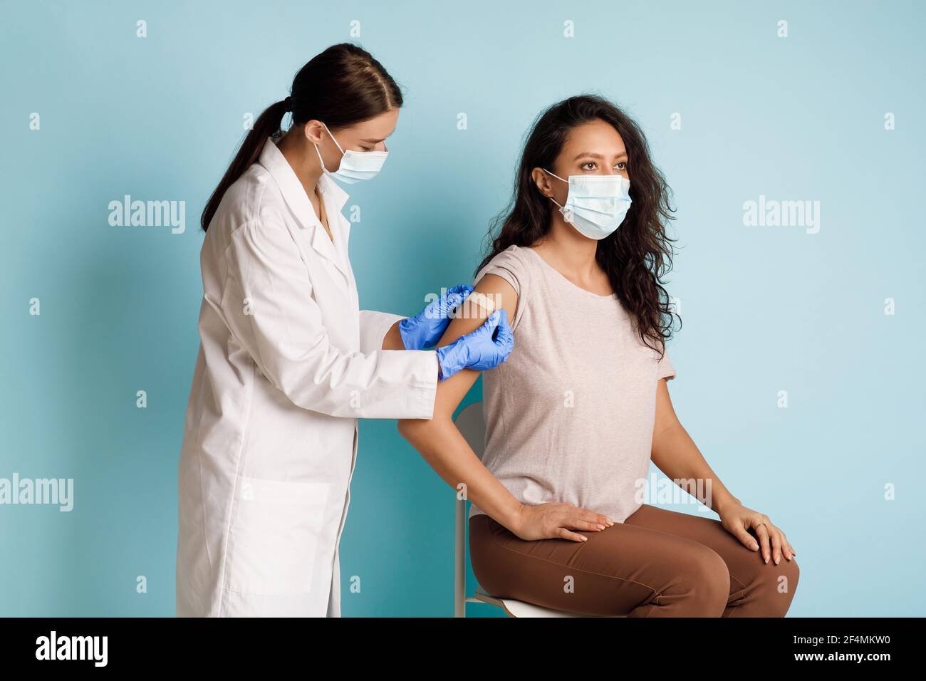 Female Getting Vaccinated, Nurse Applying Plaster On Arm, Blue ...