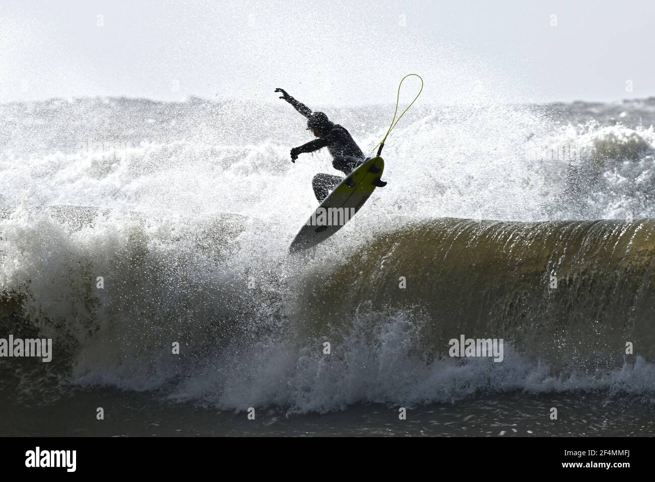 Surfer flies off the top of the wave in an aerial rotation that ...